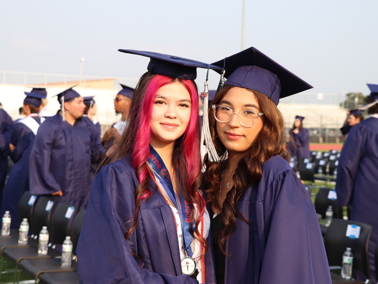 Champion seniors cross stage, turn tassels during commencement